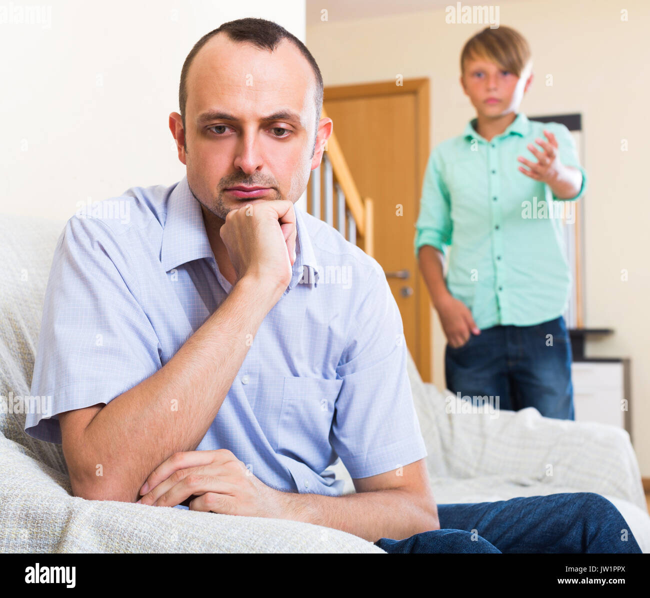 Offended man having problems with teenager son Stock Photo - Alamy