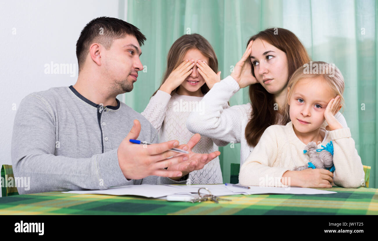 Young unhappy parents having quarrel adout documents in front of ...
