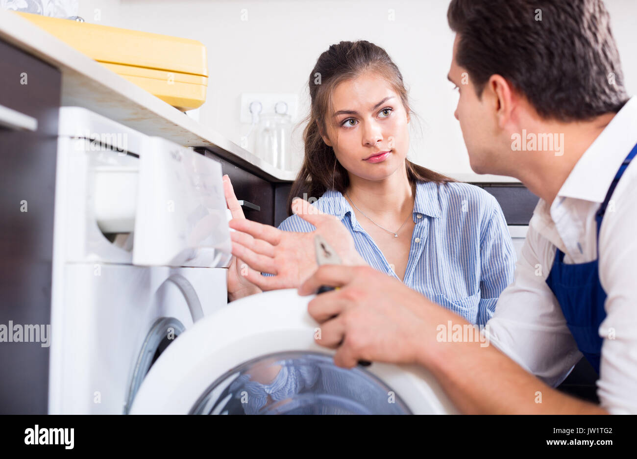 Specialist in uniform with tools and housewife washing machine Stock ...