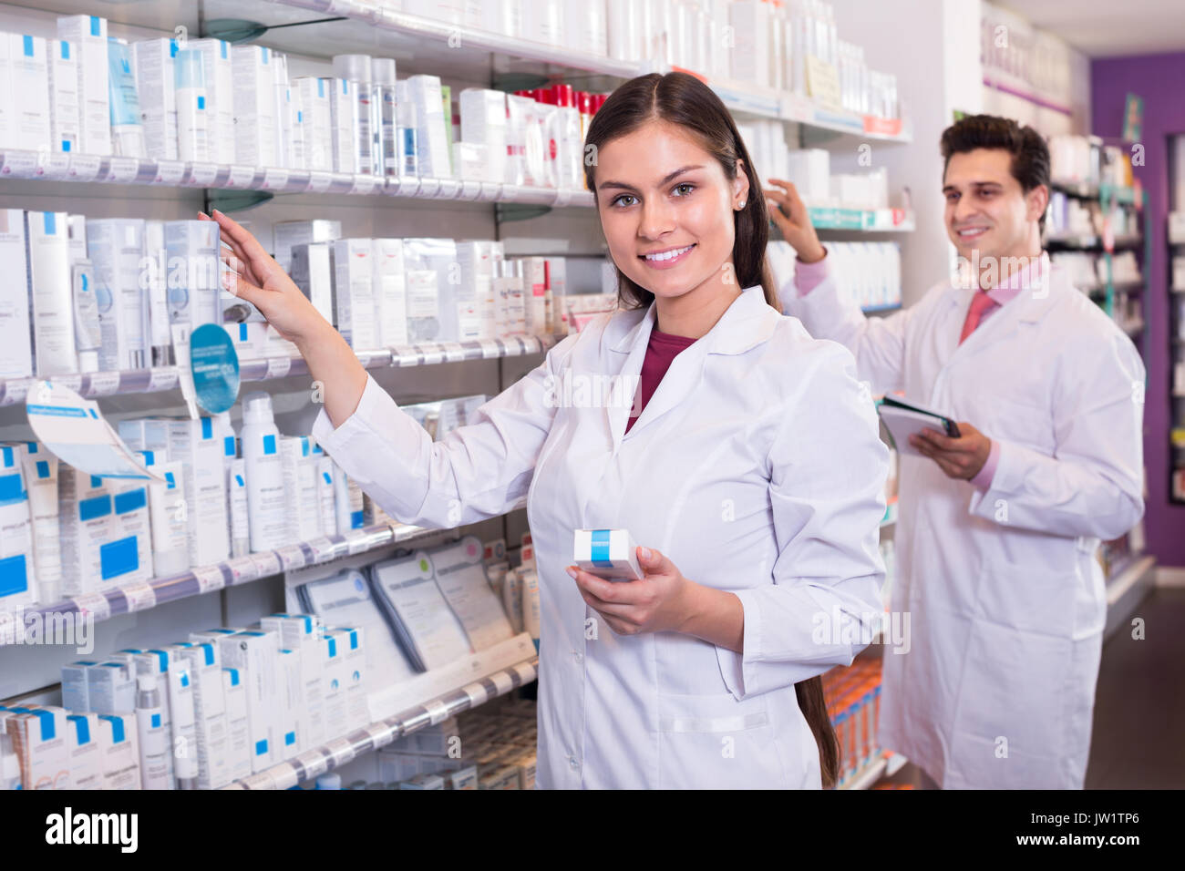 Smiling pharmacist and pharmacy staff posing in drugstore Stock Photo ...