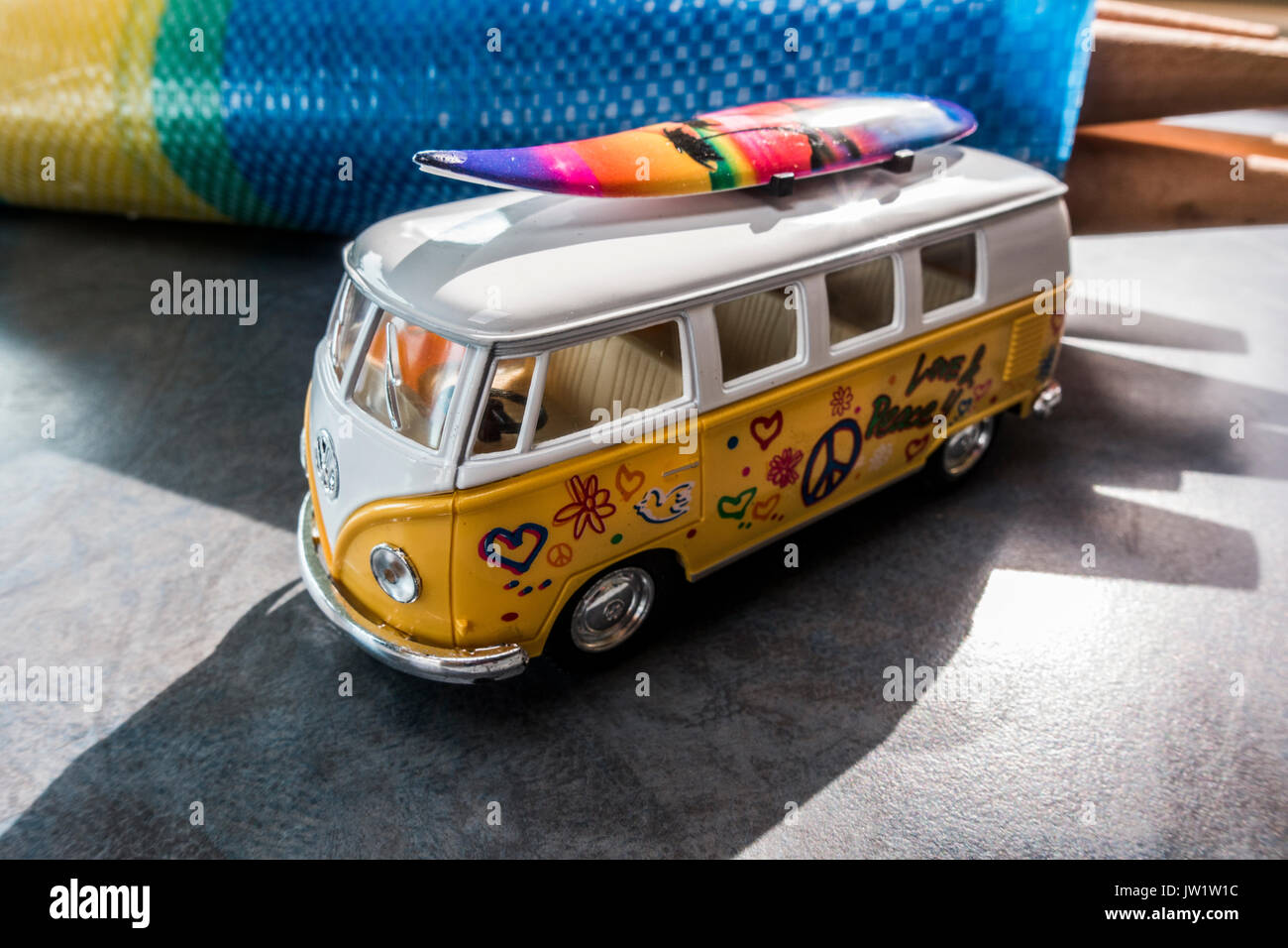 Motorhoming holiday concept with a model VW campervan and surboard on ...