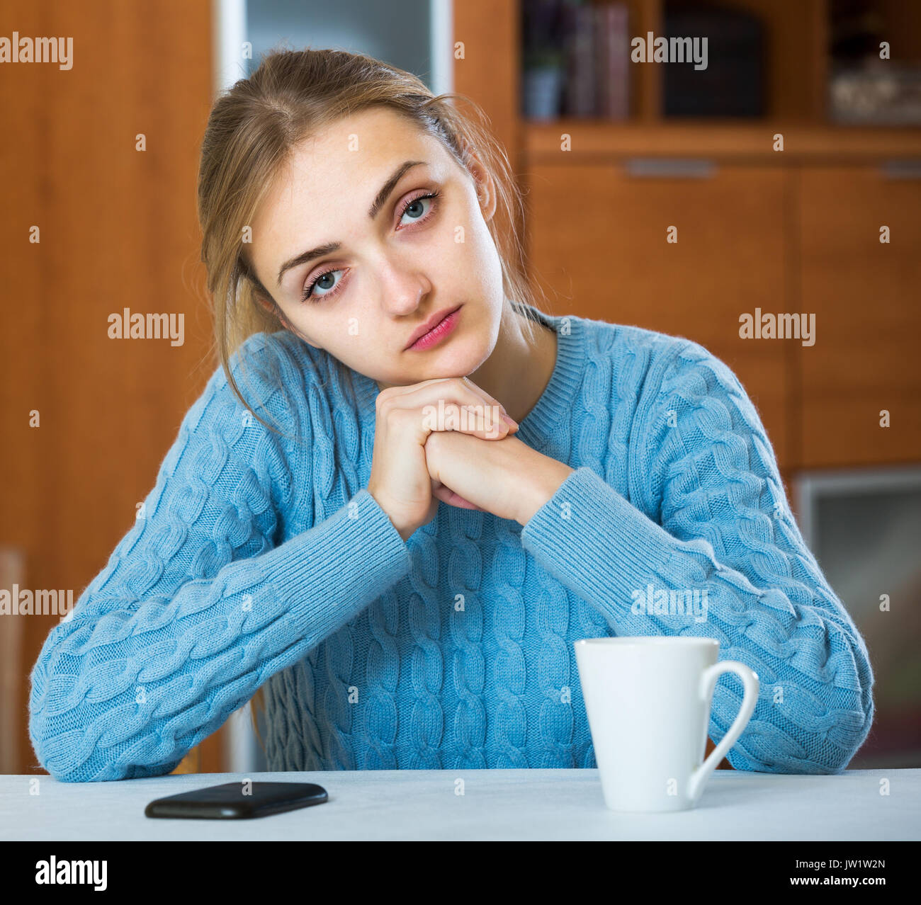 Sad girl waiting for a phone call in domestic interior Stock Photo - Alamy
