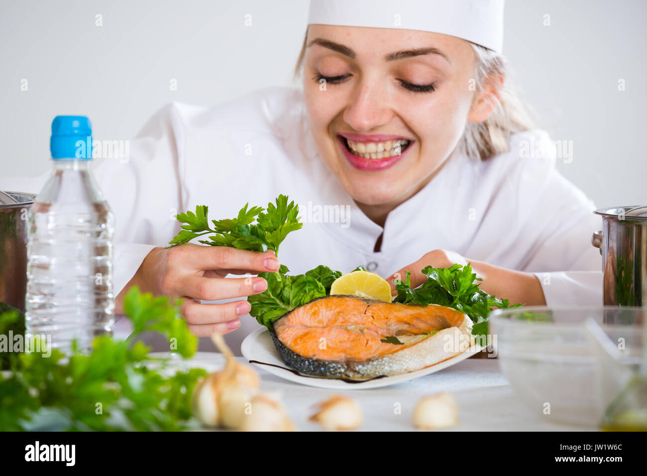 Professional chef with fried salmon fillet in commercial kitchen Stock ...