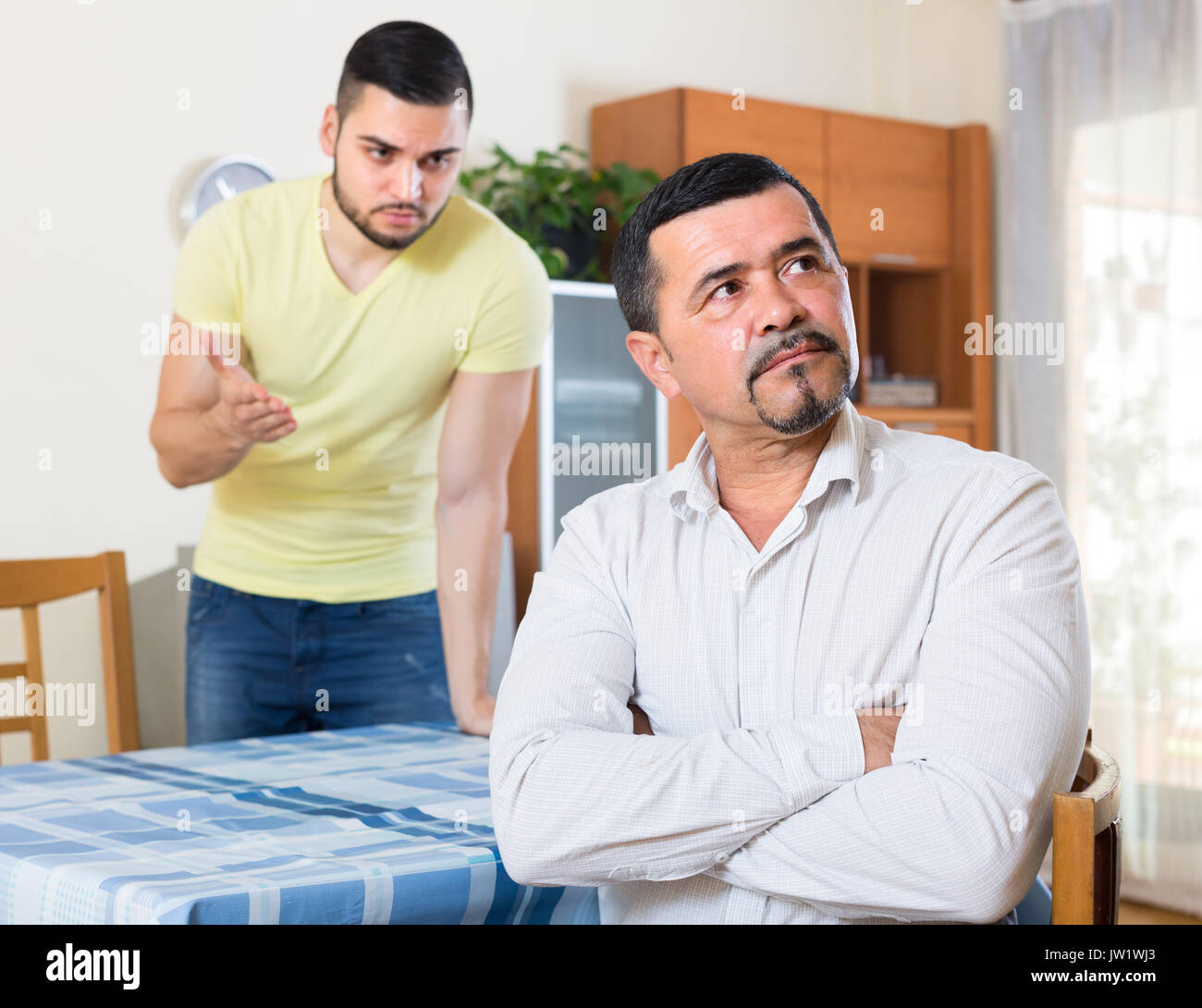 Two serious male adults having conflict indoors Stock Photo - Alamy