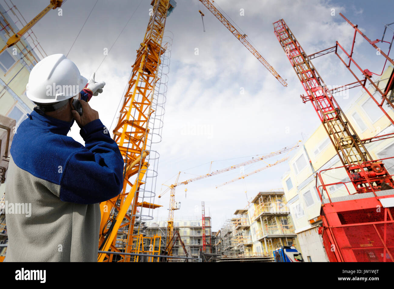 construction worker directing large mobile crane Stock Photo - Alamy