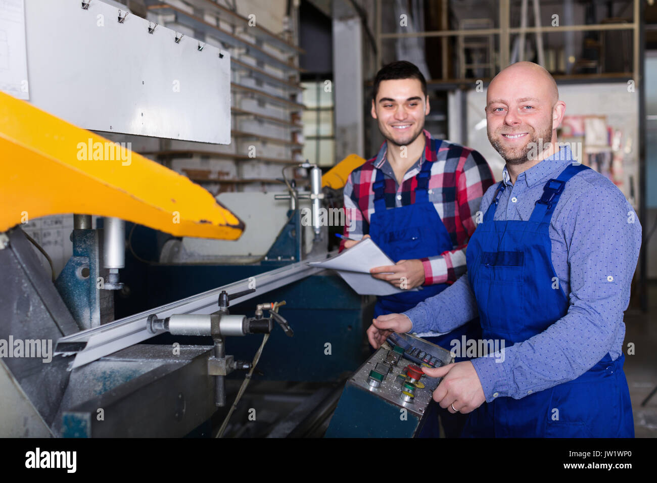 Two smiling workers posing in PVC shop indoor Stock Photo - Alamy