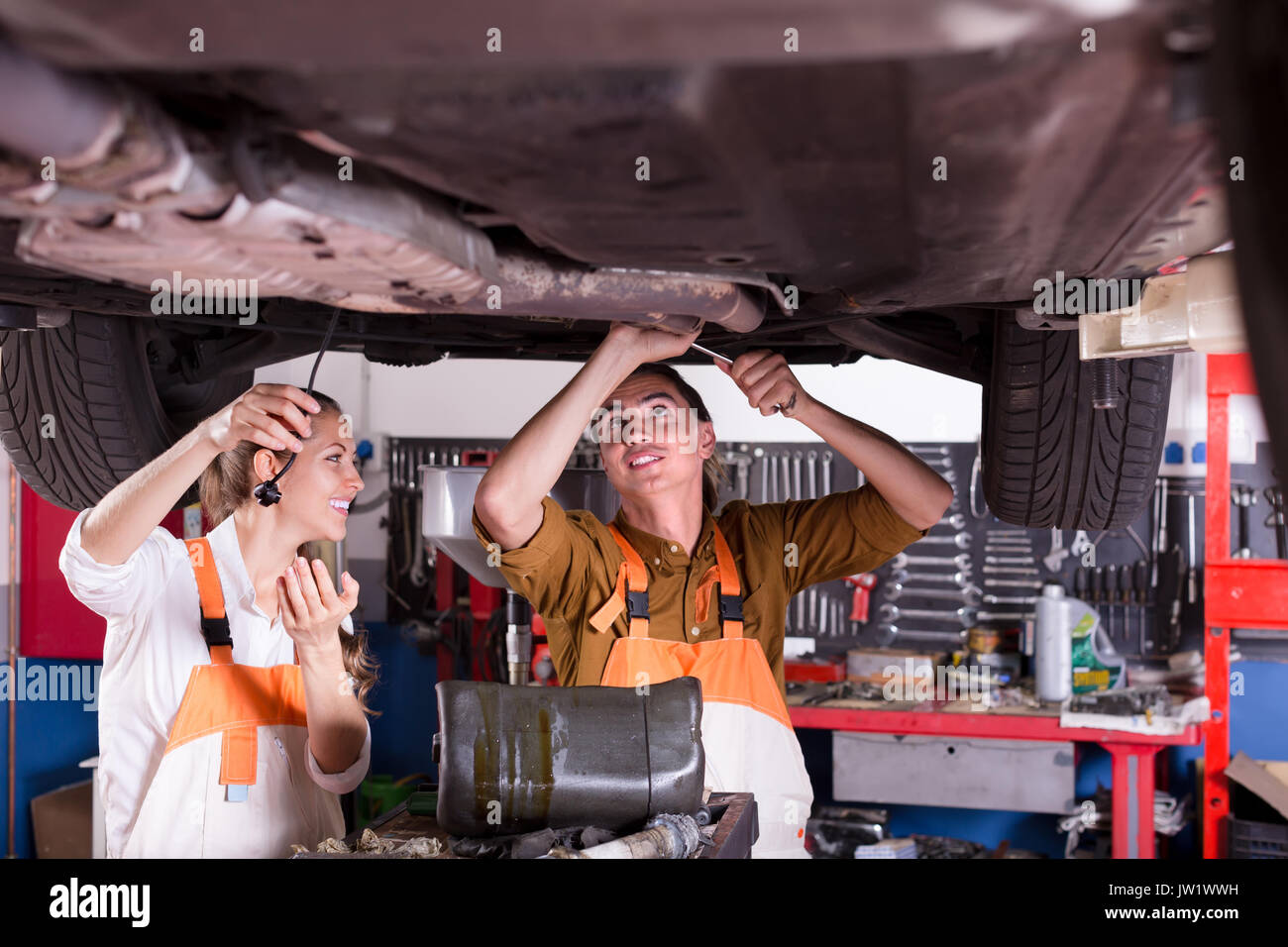 Portrait of two auto mechanics repairing broken car at garage ...