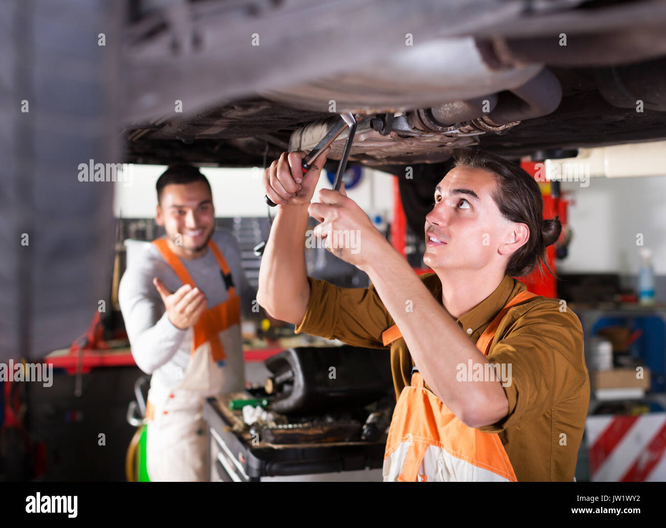 Professional positive mechanics repairing car of client Stock Photo - Alamy