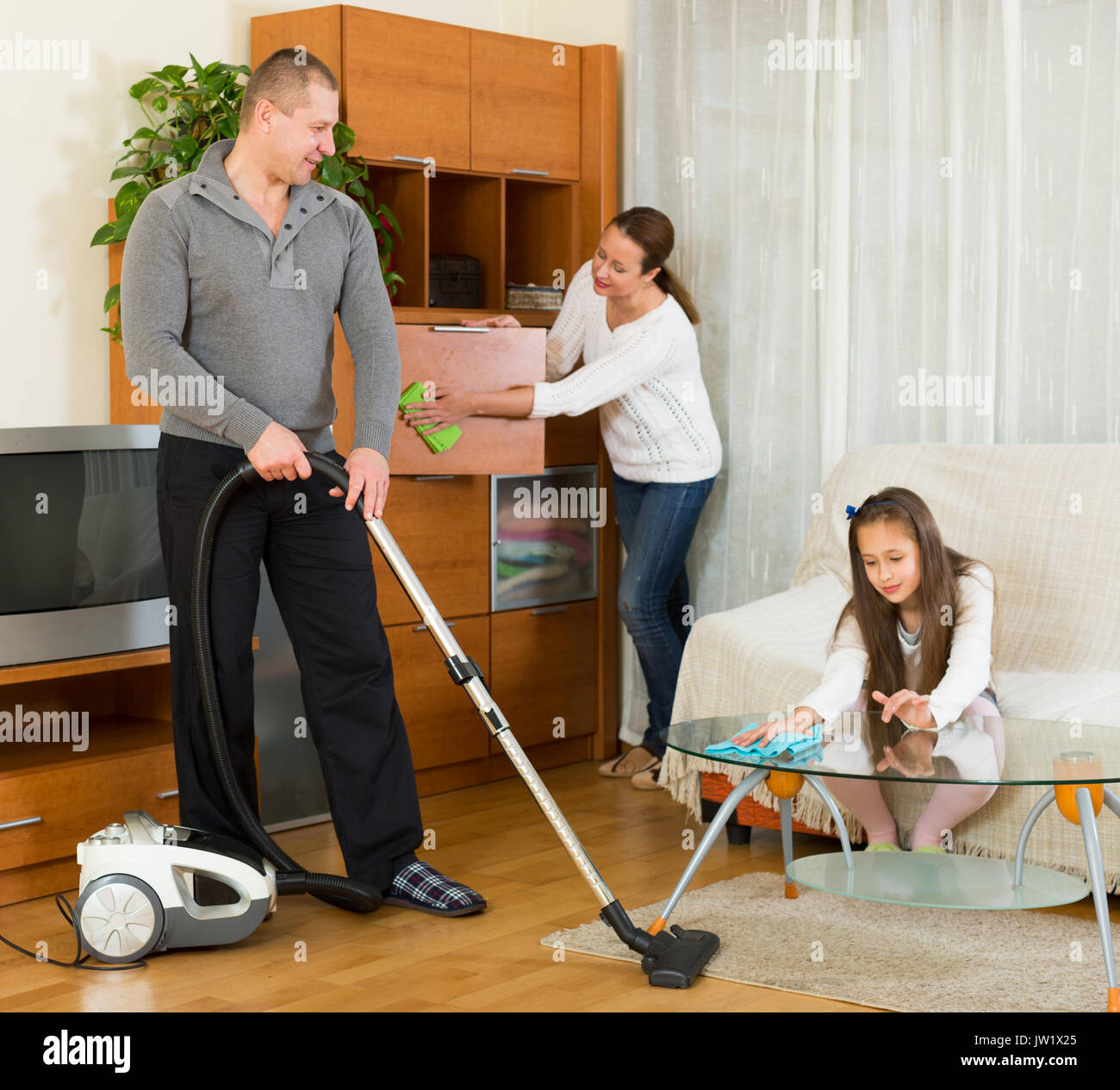 American mother, father and girl doing general cleaning indoors Stock ...