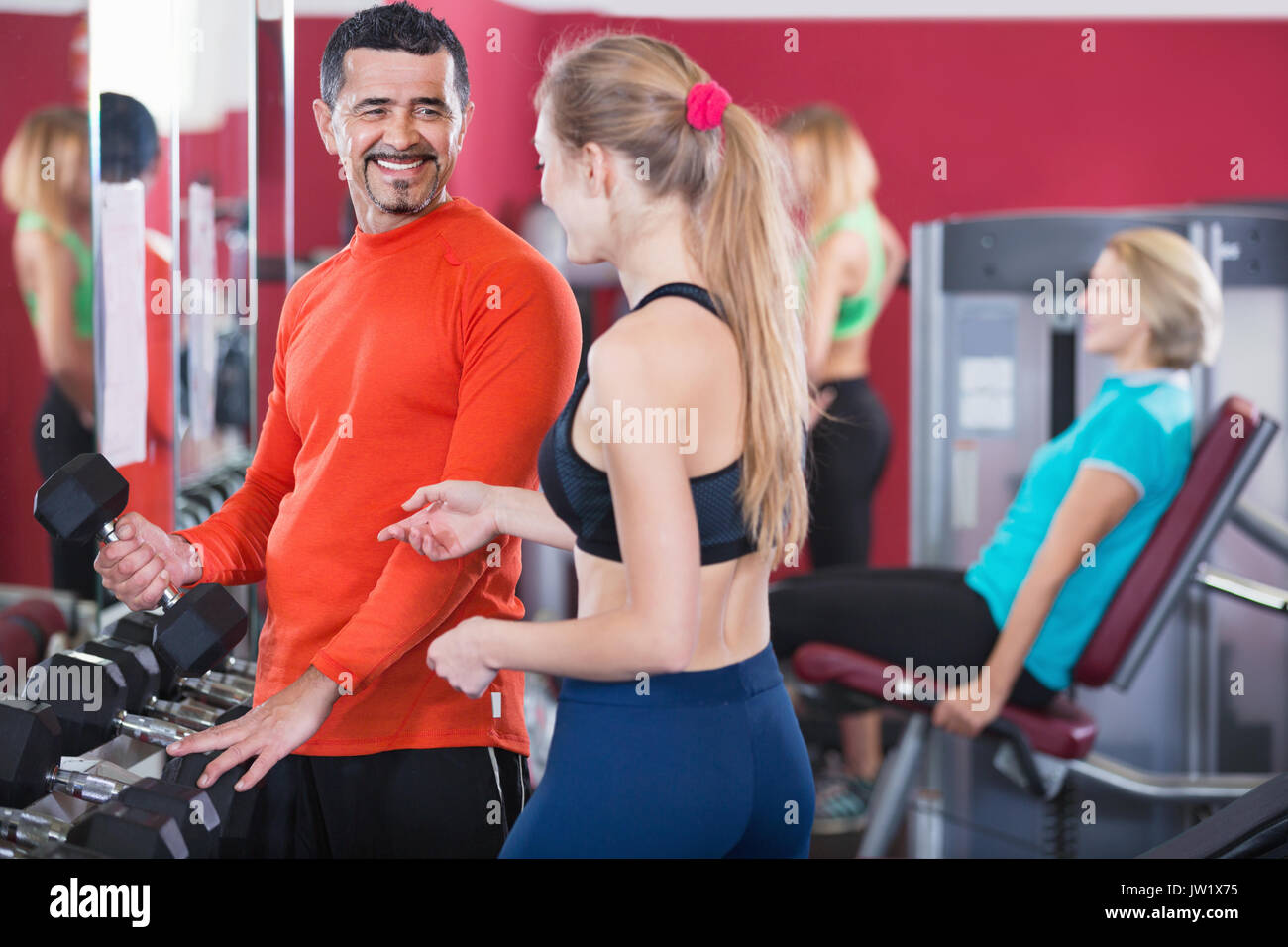 Positive smiling people weightlifting training in modern health club ...
