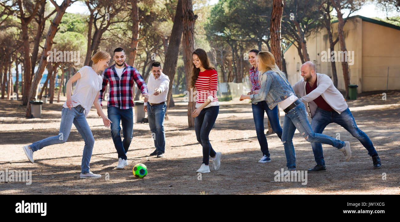 Several friends running with a ball and laughing Stock Photo - Alamy