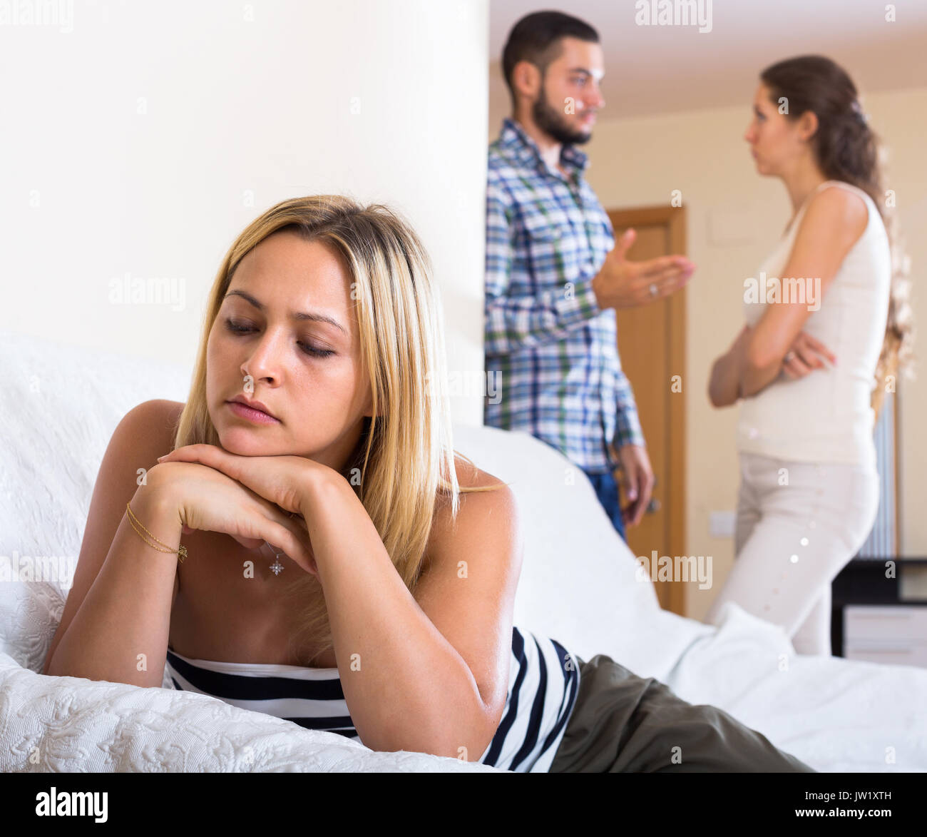 Three displeased young adults having conflict at home Stock Photo - Alamy