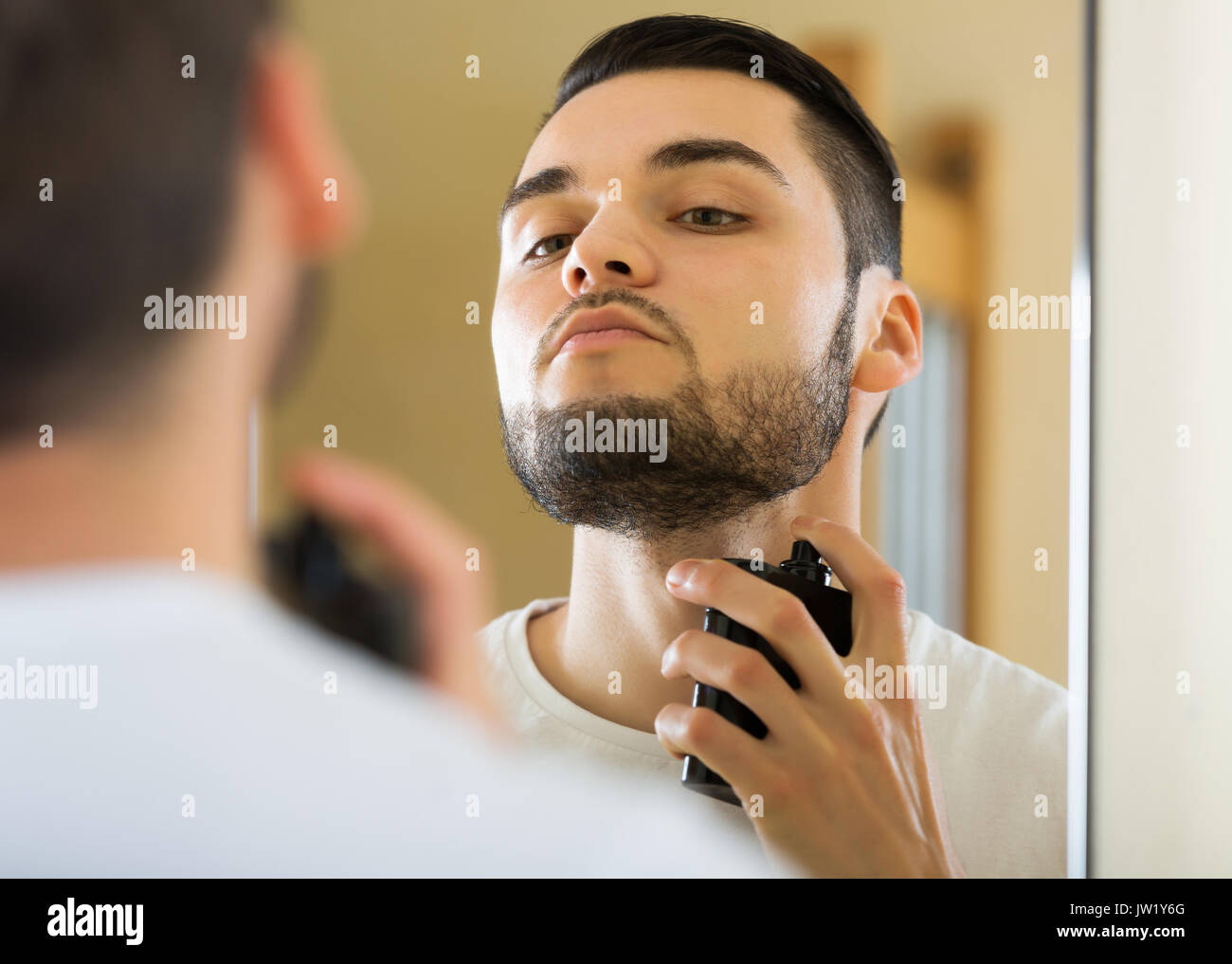 Adult attractive man spraying fragrance perfume at home Stock Photo - Alamy