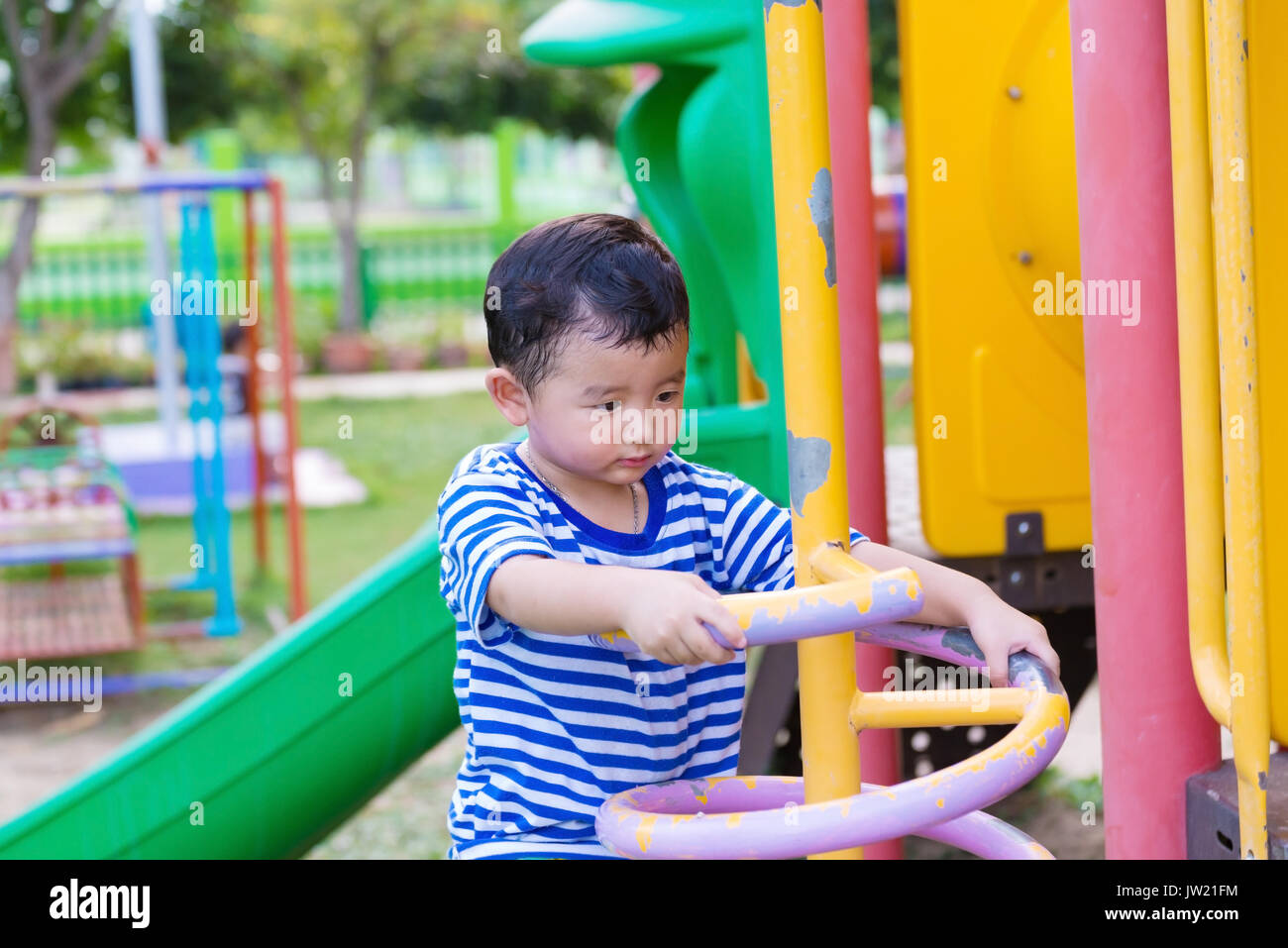 Active little child playing climbing spring metal at school yard ...