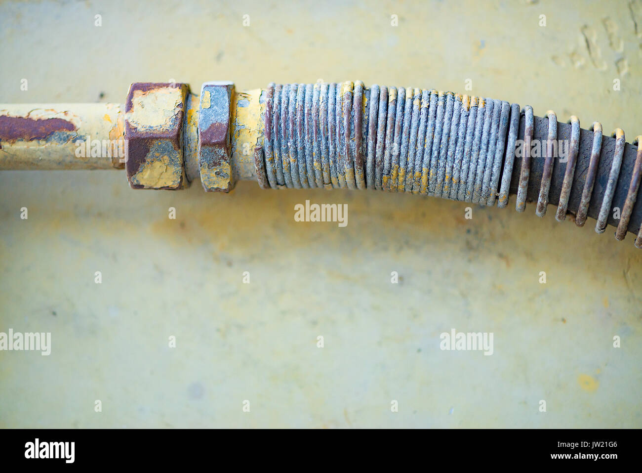 old hydraulic hose with rusty coil spring at tractor for background ...