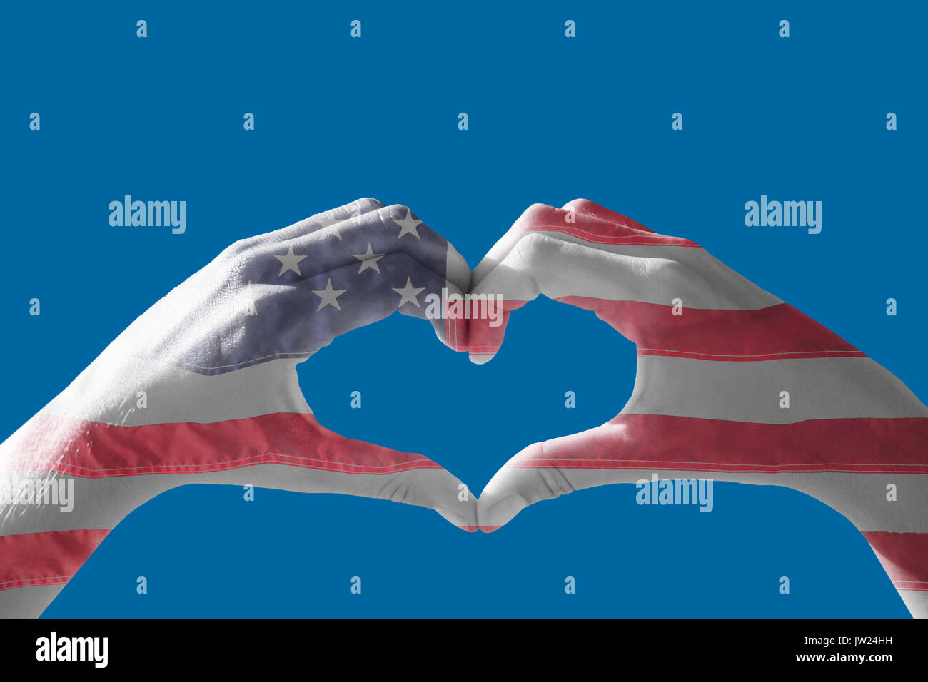 Hands making heart shape on the beach against american national flag ...