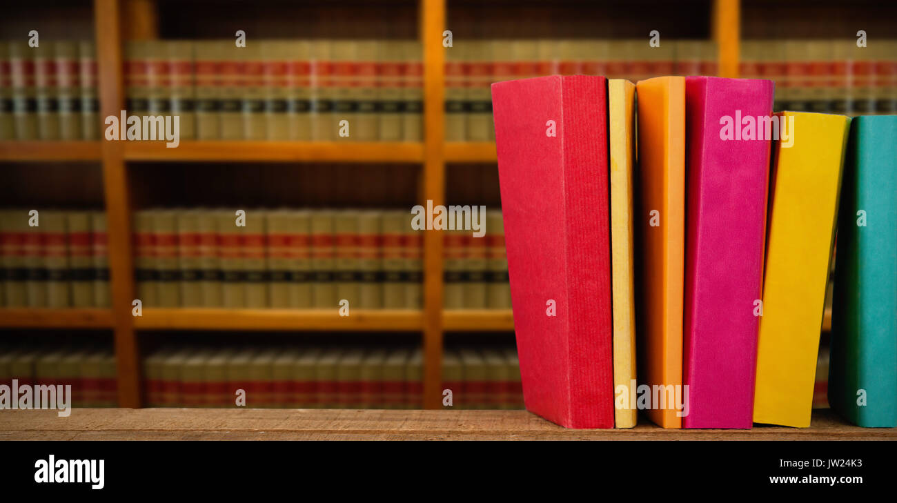 Colorful books arranged on table against bookshelf in school Stock ...