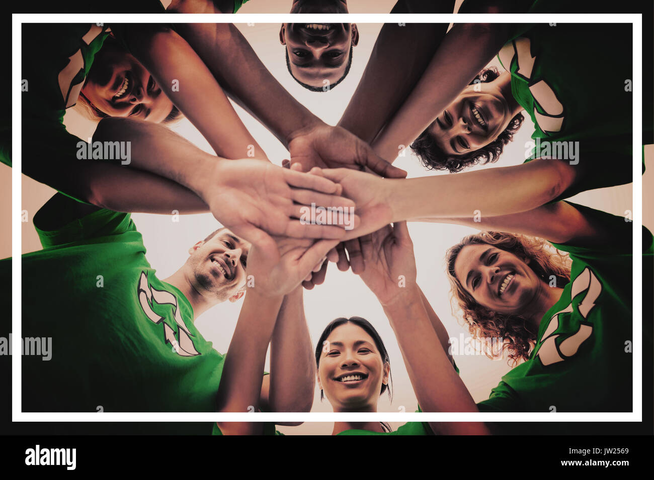 Smiling group of activists piling up their hands on white background ...