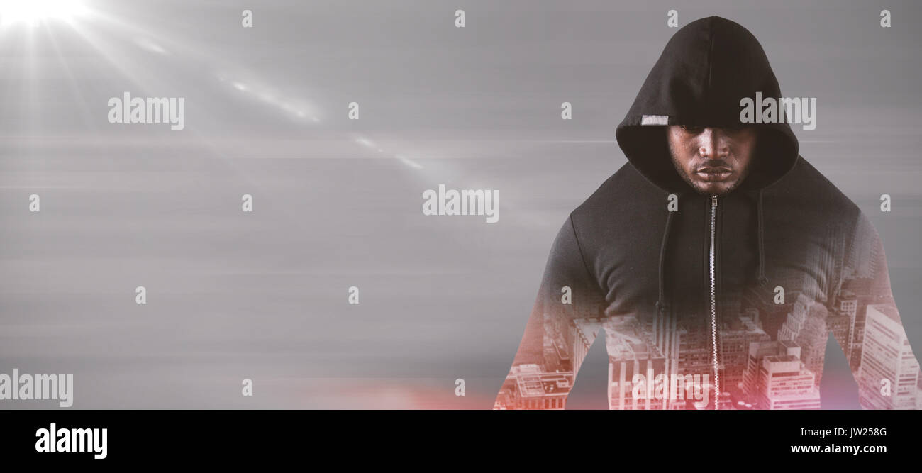 Male robber in black hoodie standing against gray abstract image Stock ...