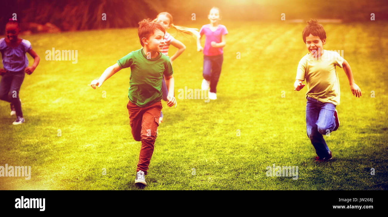 Pupils running on grassy field at elementary school campus Stock Photo ...