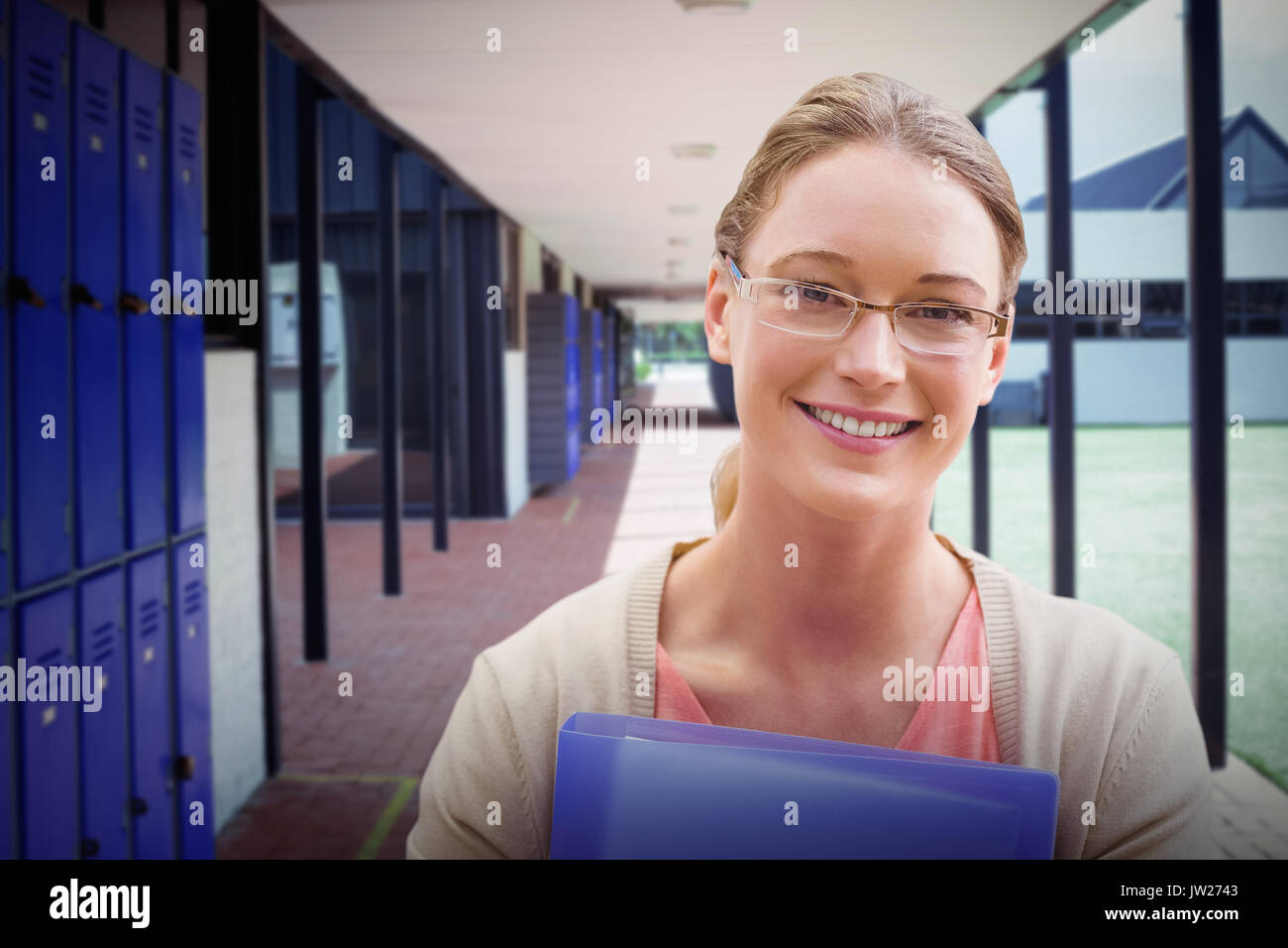 Teaching student smiling against empty corridor at school Stock Photo ...