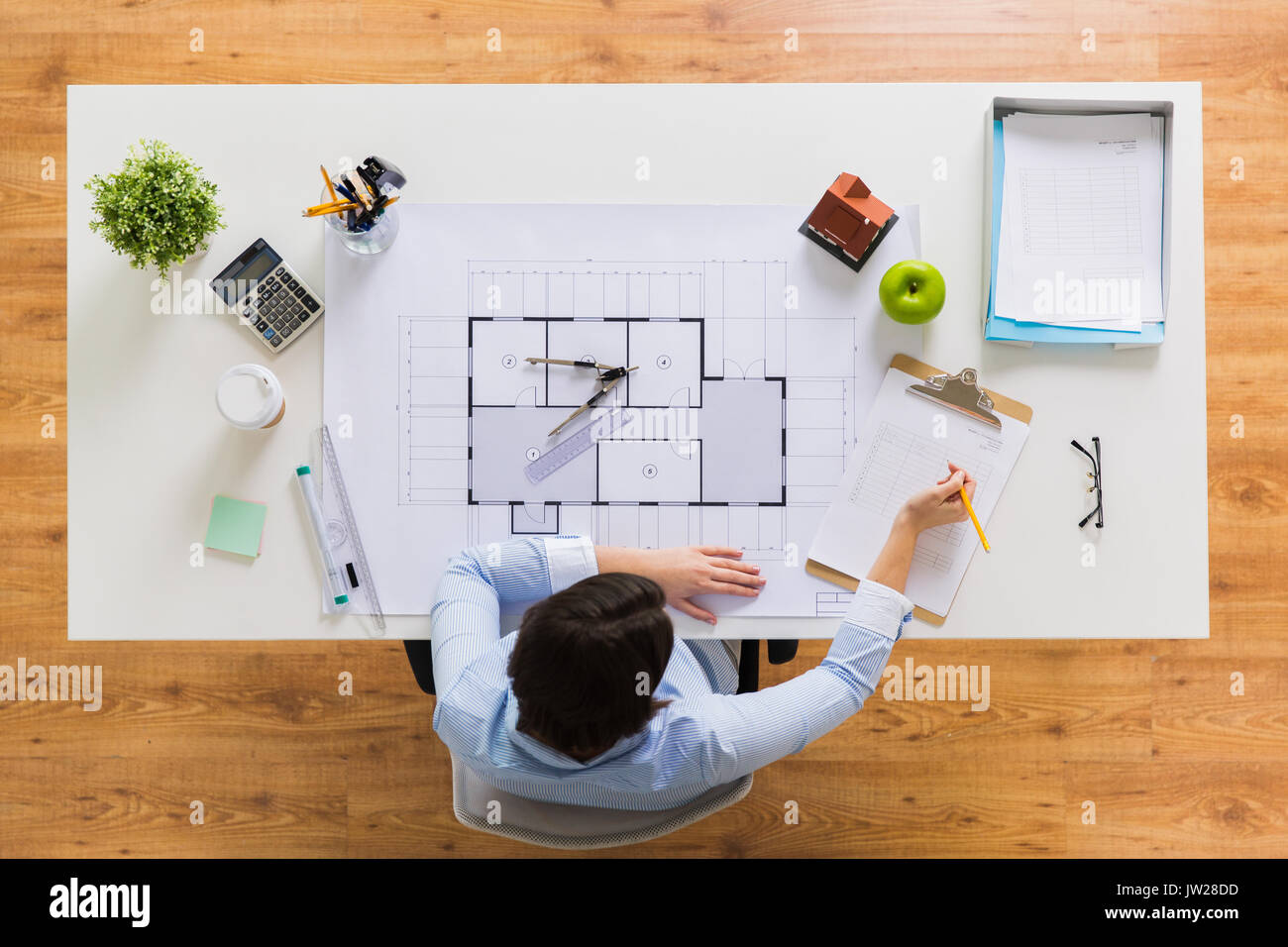 architect with blueprint writing to clipboard Stock Photo - Alamy