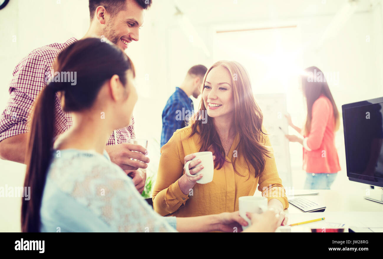 happy creative team drinking coffee at office Stock Photo - Alamy