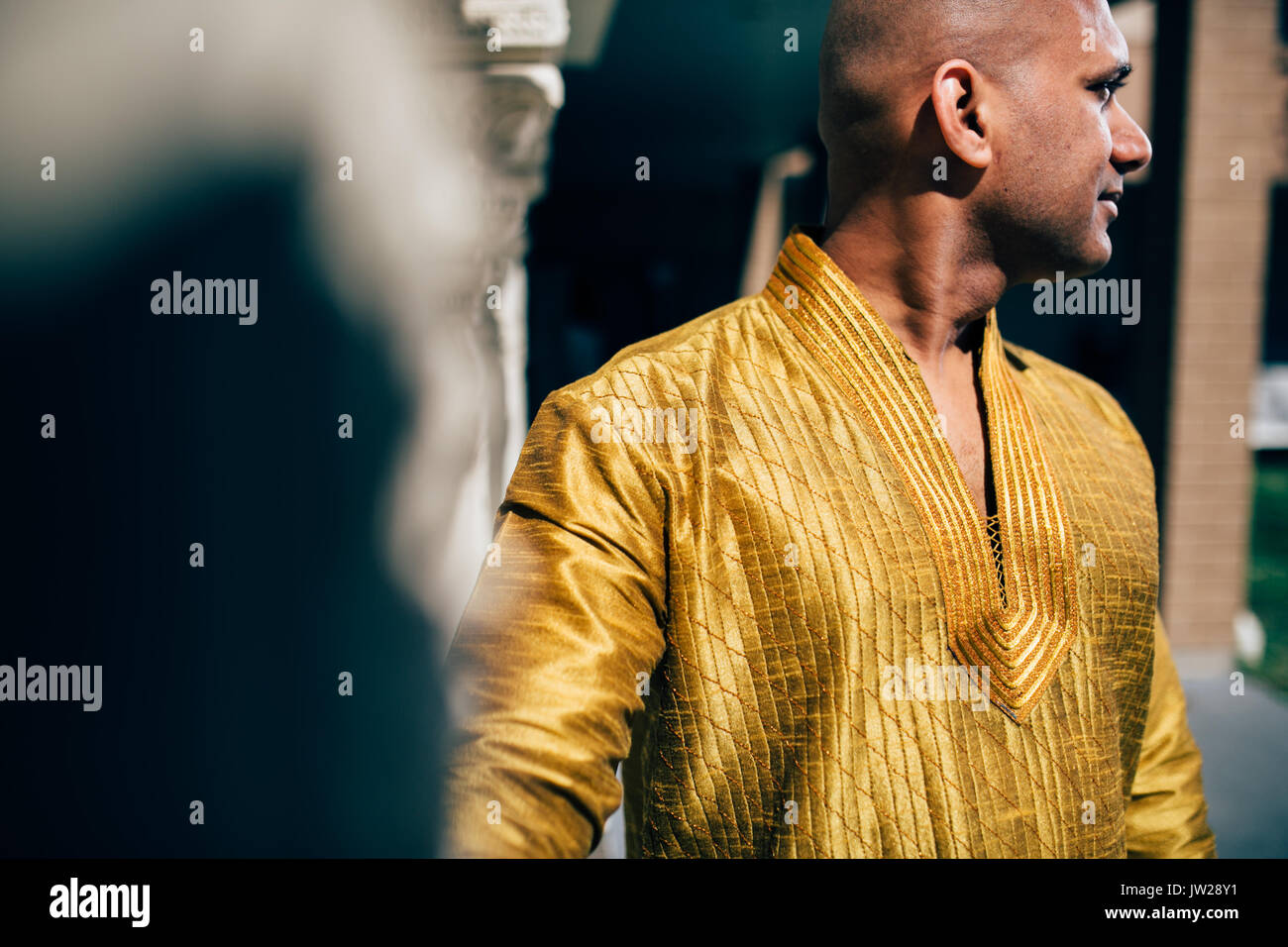 The handsome Indian man wears a gold kurta and posed at a temple Stock ...