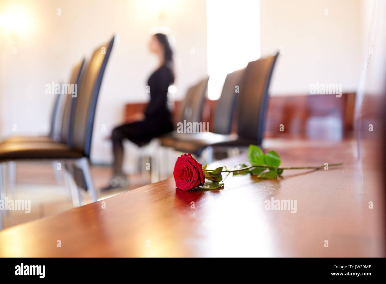 red roses and woman crying at funeral in church Stock Photo - Alamy