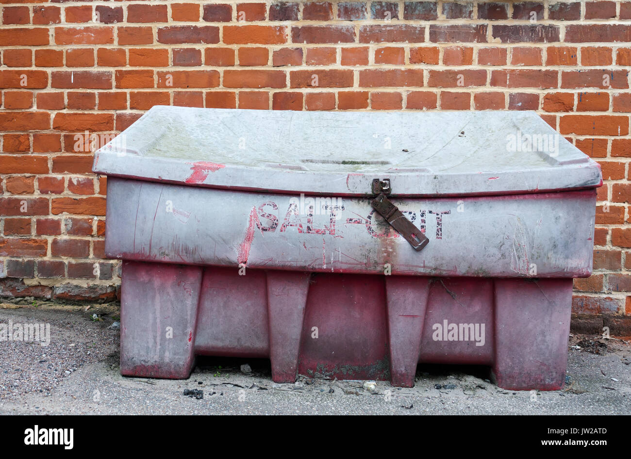 an old and retro looking red salt grit locked container outside; UK ...