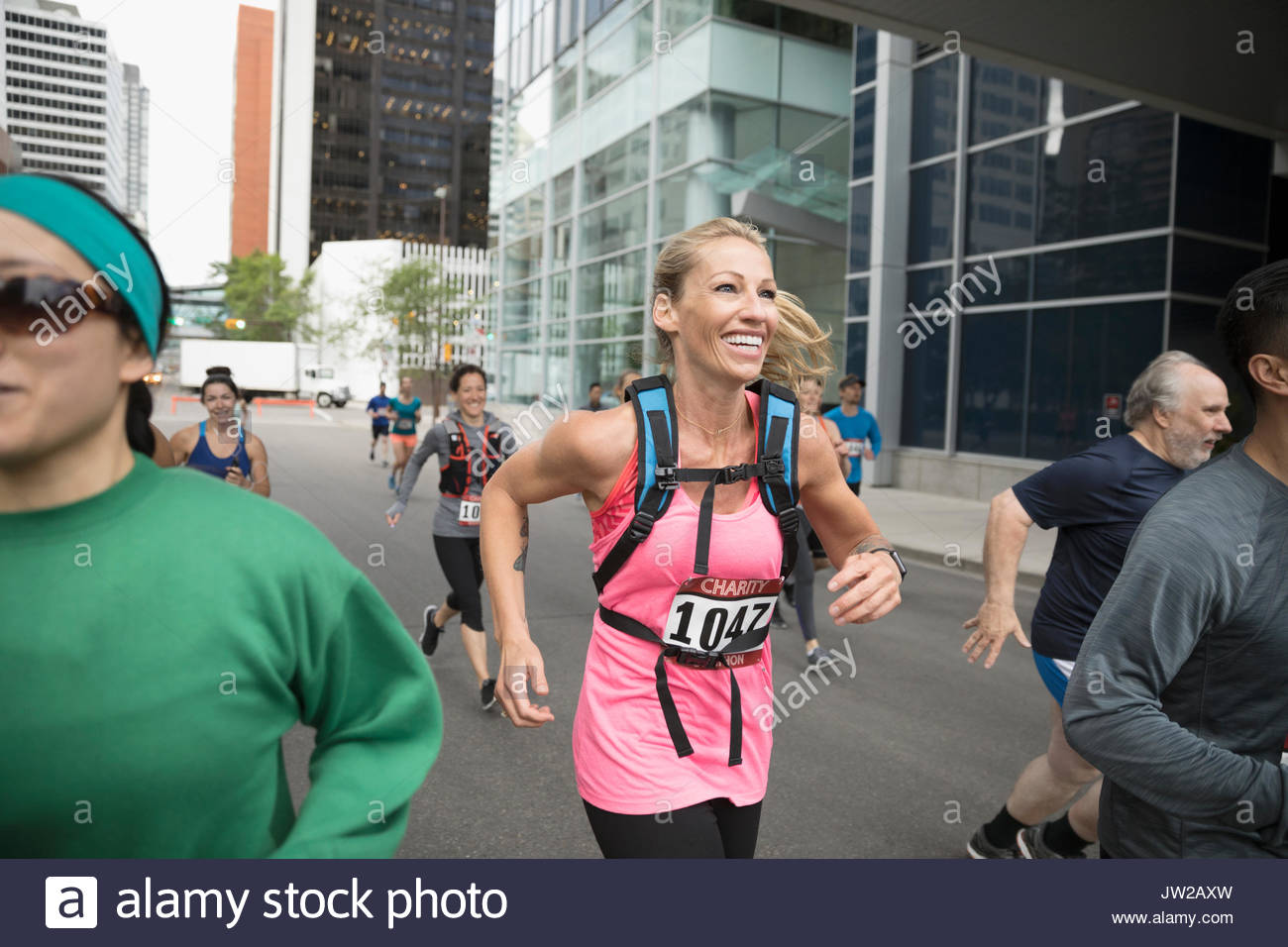 Enthusiastic female runner running on urban street hi-res stock ...