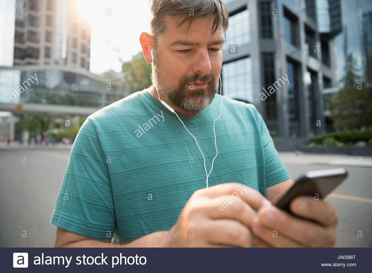 Man standing street listening mp3 player hi-res stock photography and ...