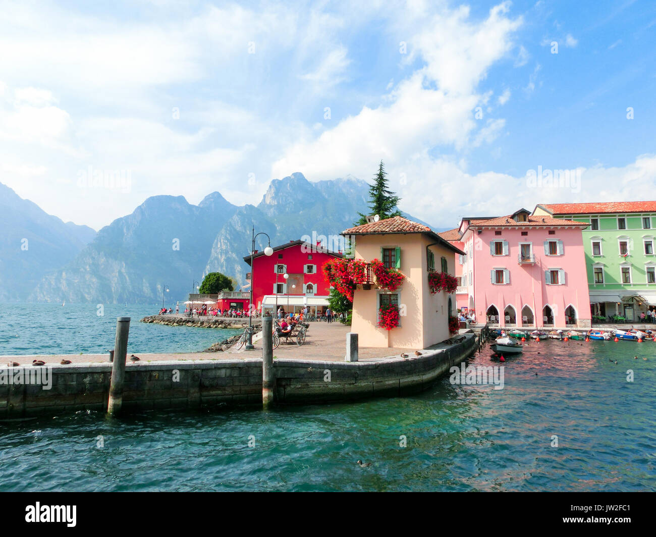 Torbole, Italy - Lake Garda boardwalk with houses, tourists and boats ...