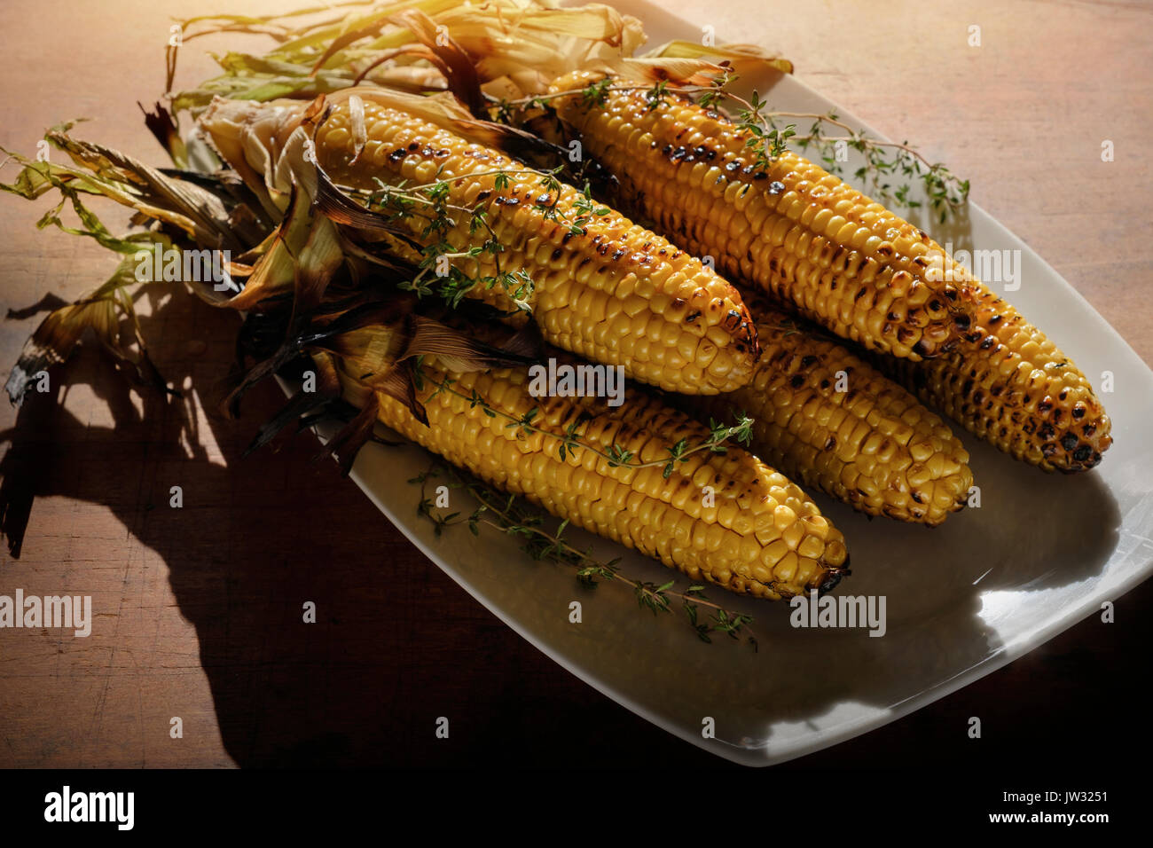 Grilled corn on cob with thyme on plate Stock Photo - Alamy
