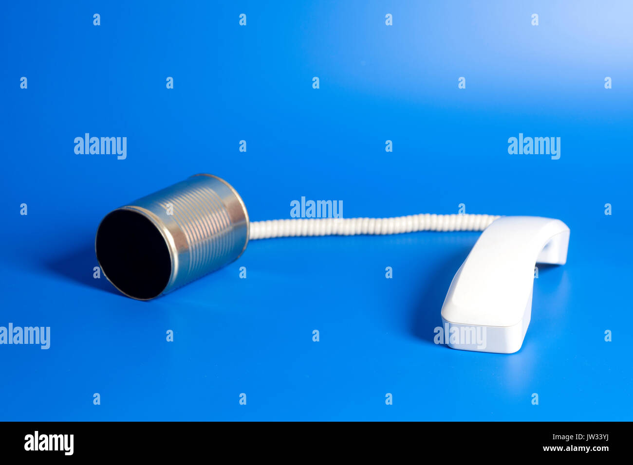 Tin can phone with handset on blue background Stock Photo - Alamy