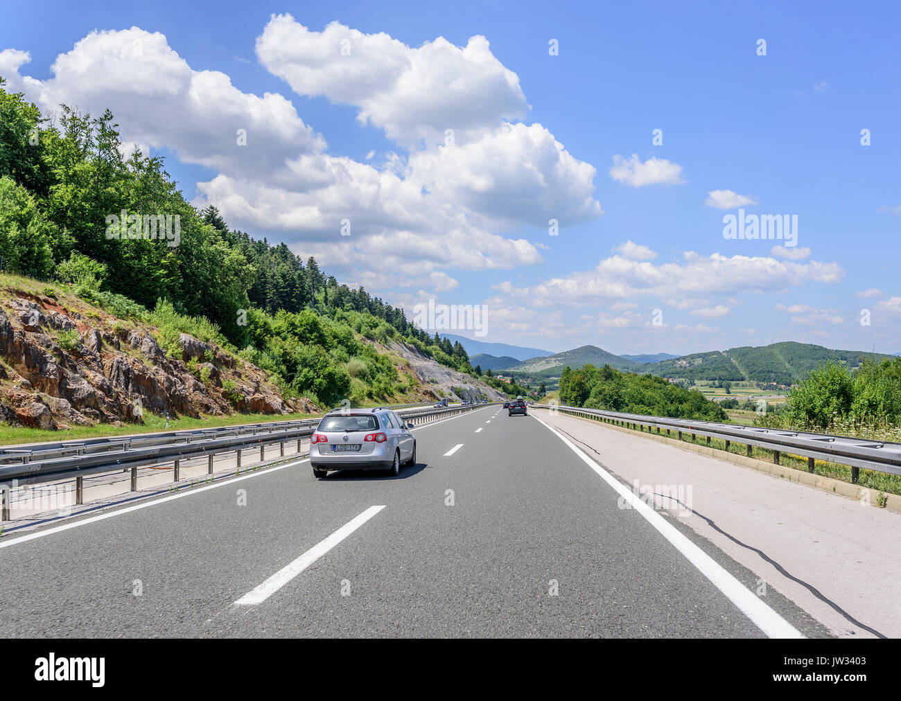 Cars speeding on the Autobahn among mountain scenery Stock Photo - Alamy