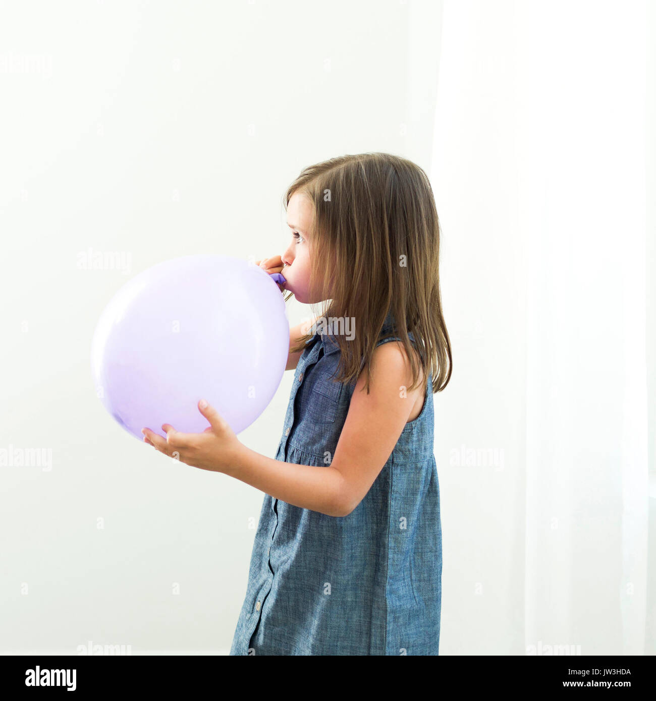 Girl blowing up balloon hi-res stock photography and images - Alamy