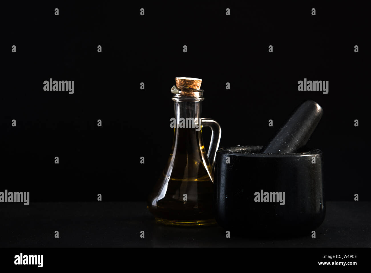 Granite mortar for herbs and olive oil on dark stone background Stock ...