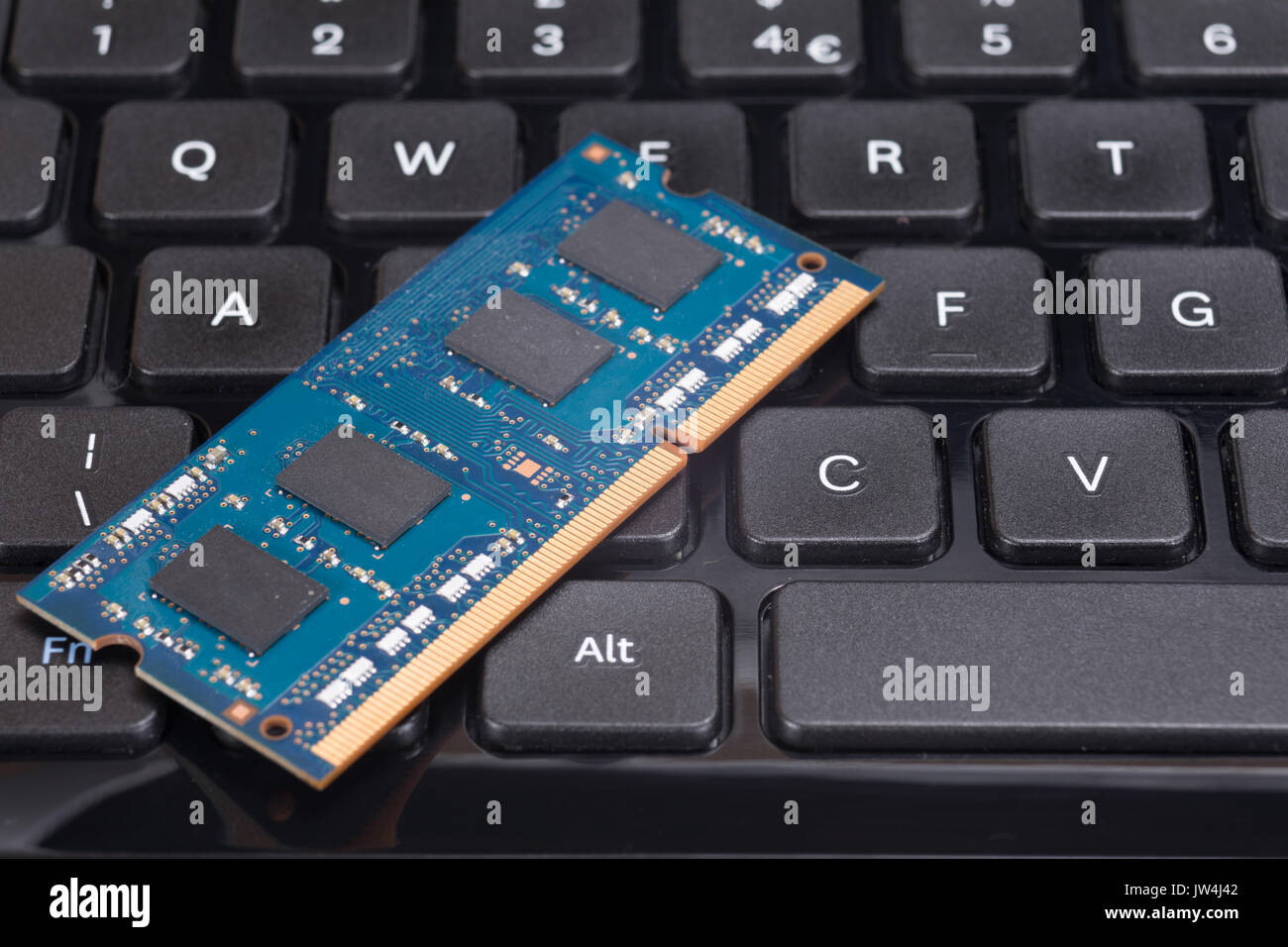 Close up of a blue computer chip circuit board on a black keyboard ...