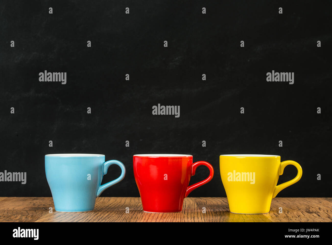 three colors coffee cups with blue red yellow showing design ...