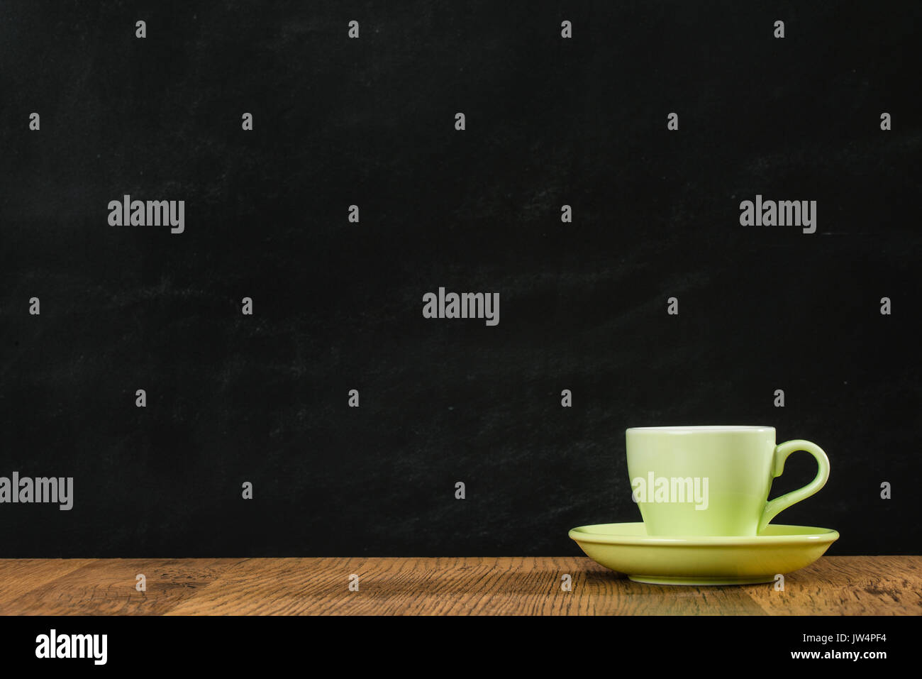 warm green color coffee cup set on wooden floor table desk filled with ...