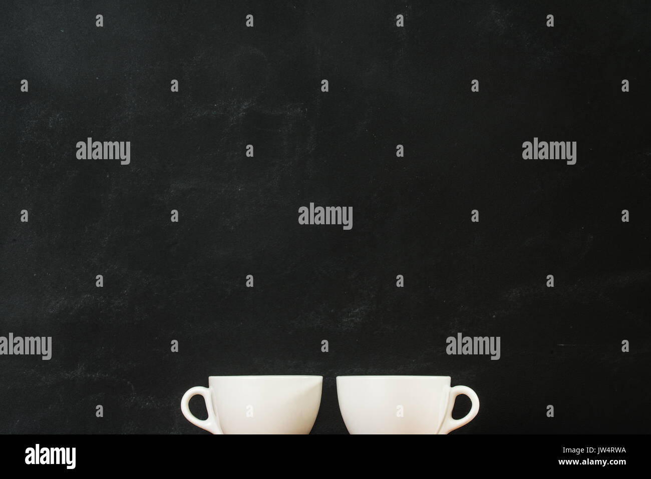 half coffee cups showing at blackboard wall background bottom with ...