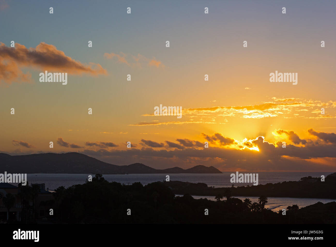 Sun about to appear above the clouds at sunset on St Thomas Island, US ...