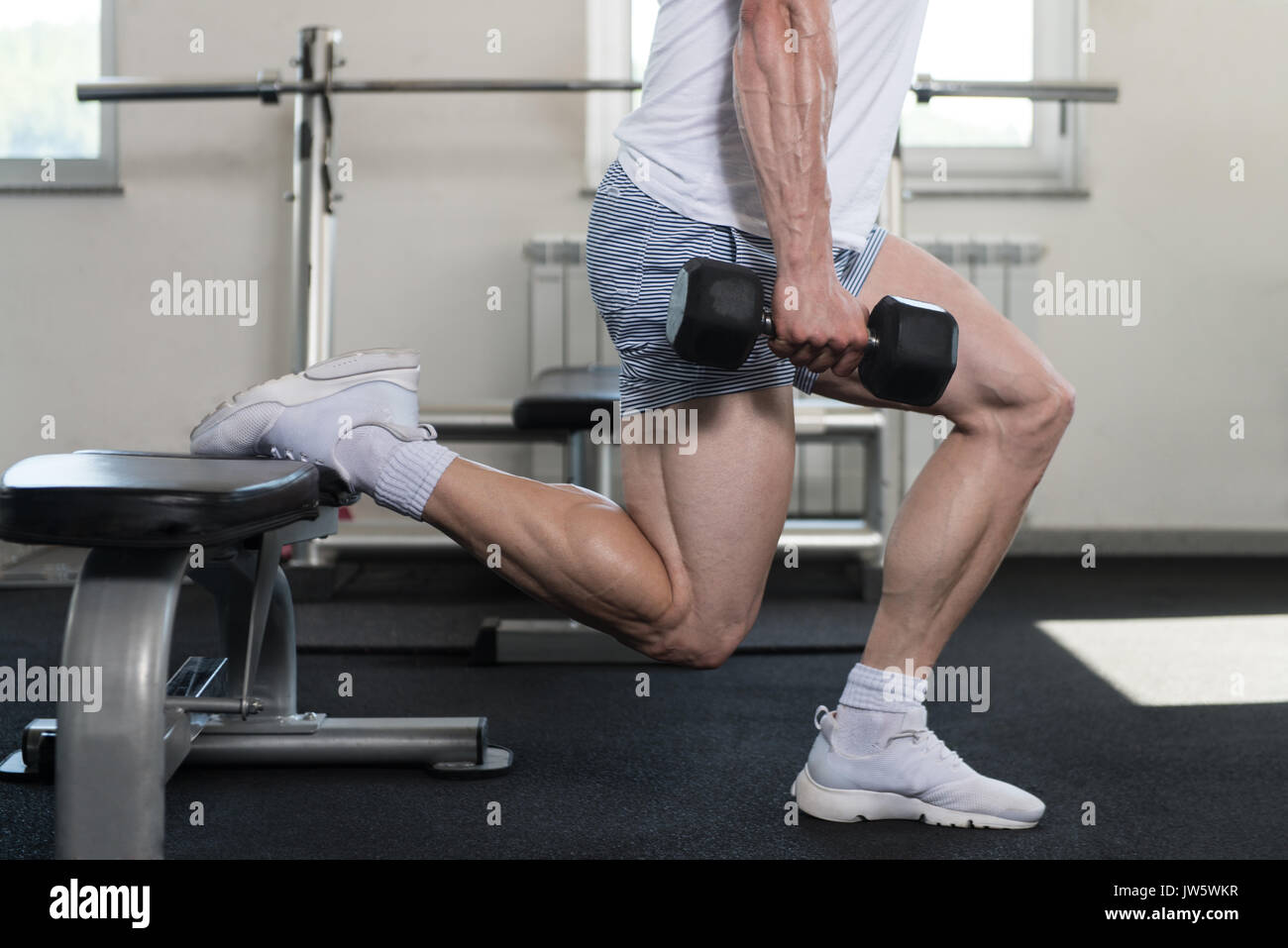 Athlete Working Out Hamstrings In A Gym With Dumbbells Stock Photo - Alamy
