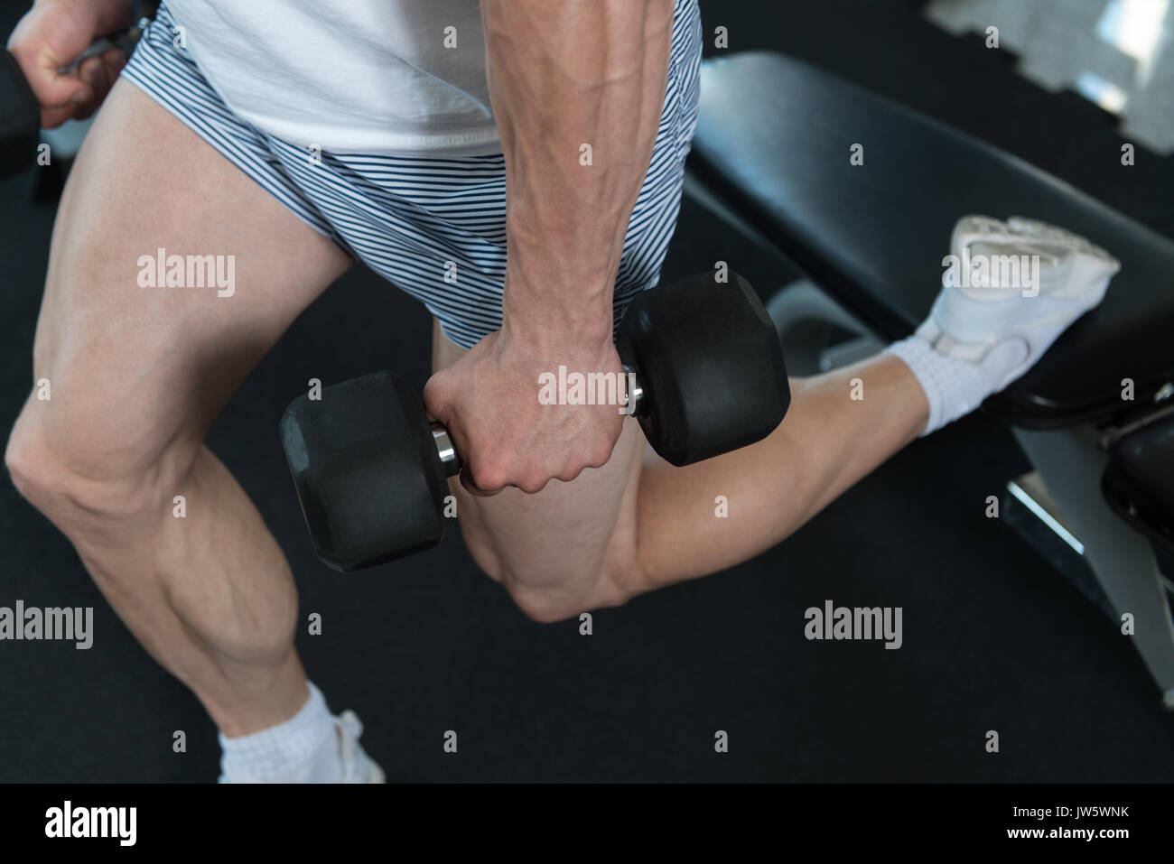 Athlete Working Out Hamstrings In A Gym With Dumbbells Stock Photo - Alamy