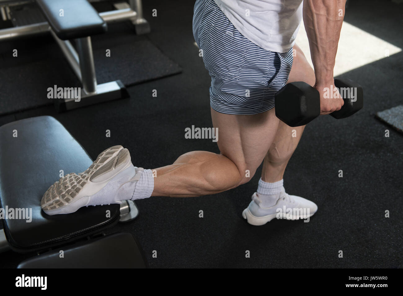 Athlete Working Out Hamstrings In A Gym With Dumbbells Stock Photo - Alamy