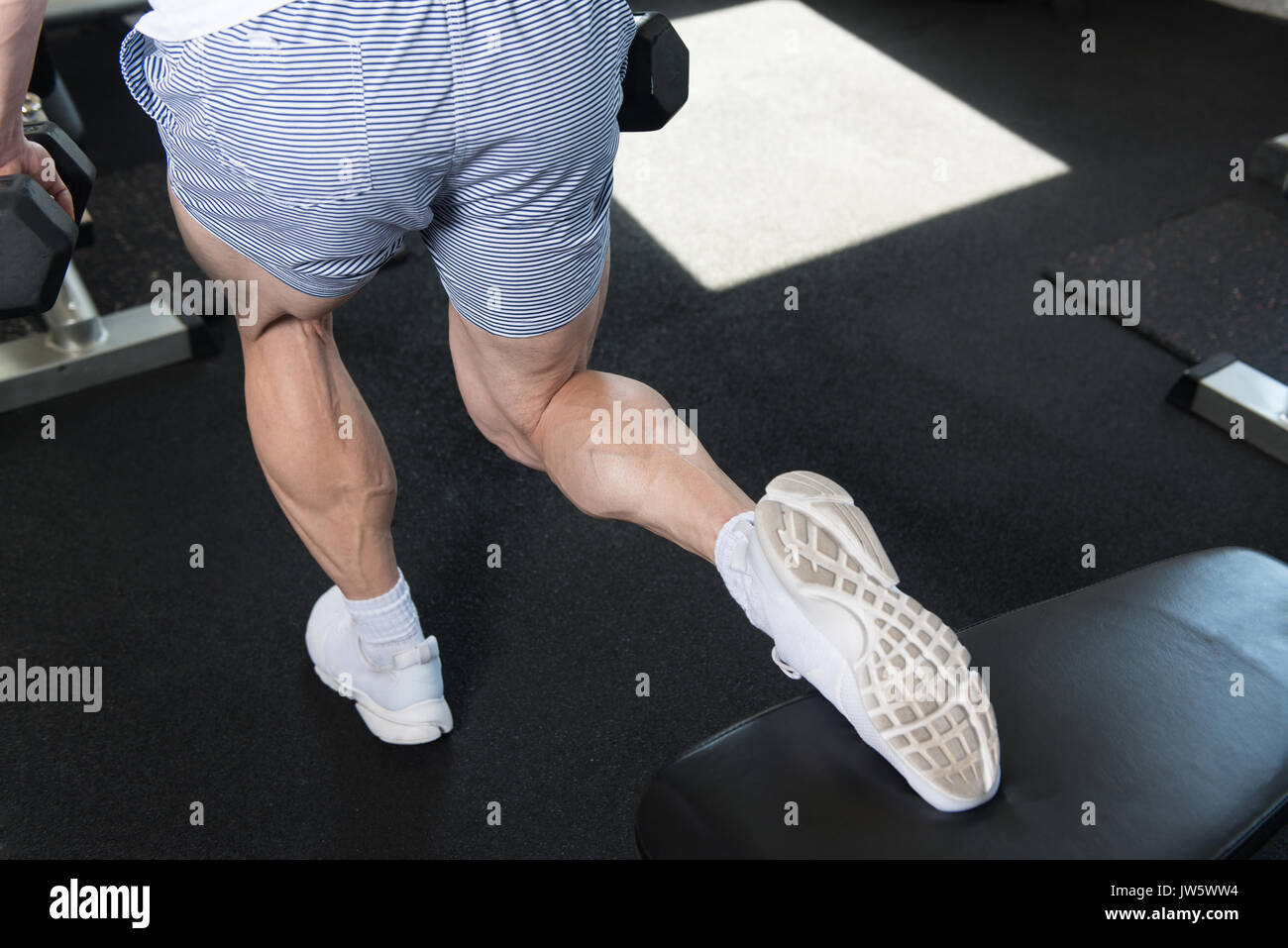 Athlete Working Out Hamstrings In A Gym With Dumbbells Stock Photo - Alamy