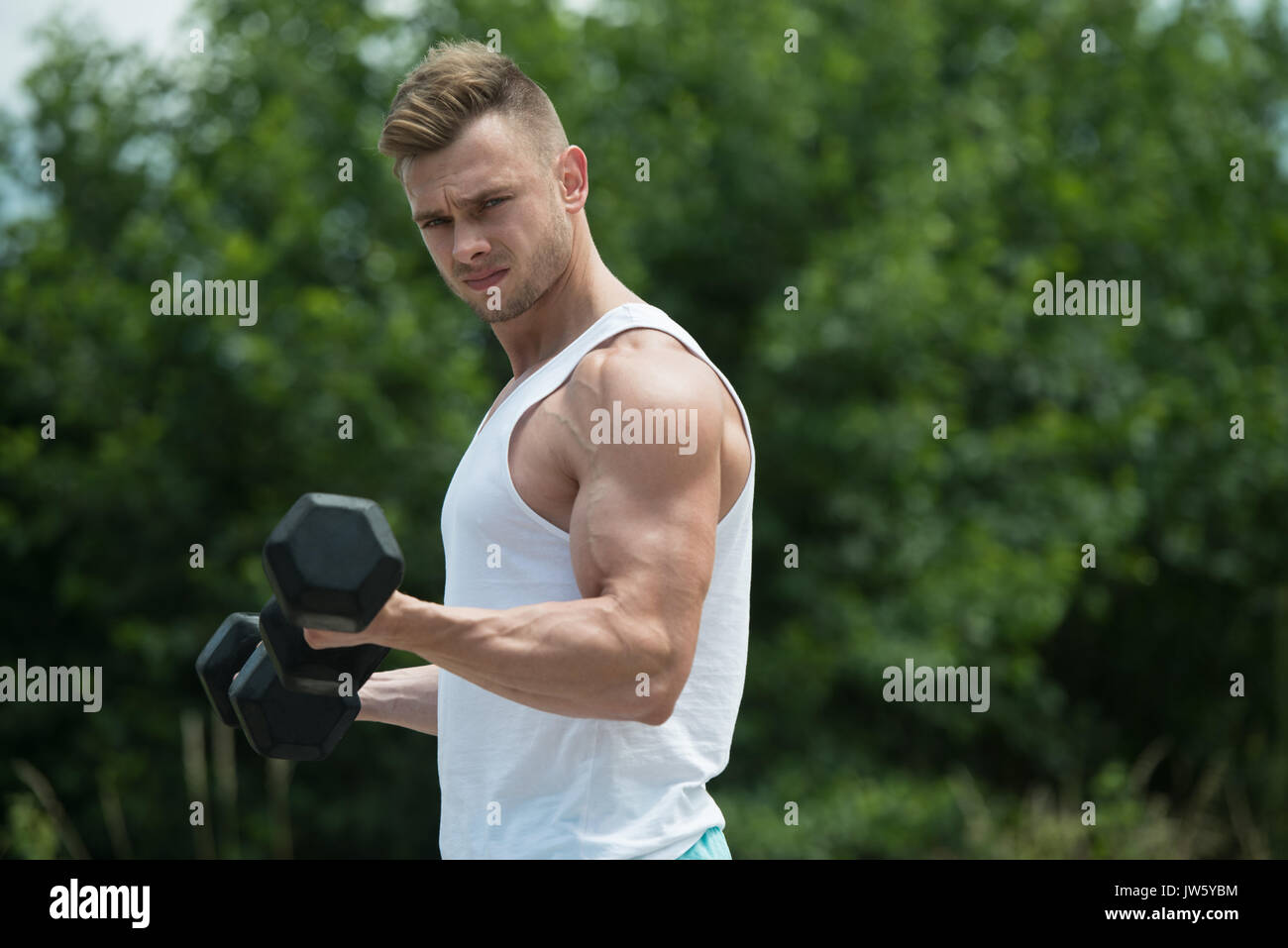Athlete Working Out Biceps In Nature - Dumbbell Concentration Curls ...