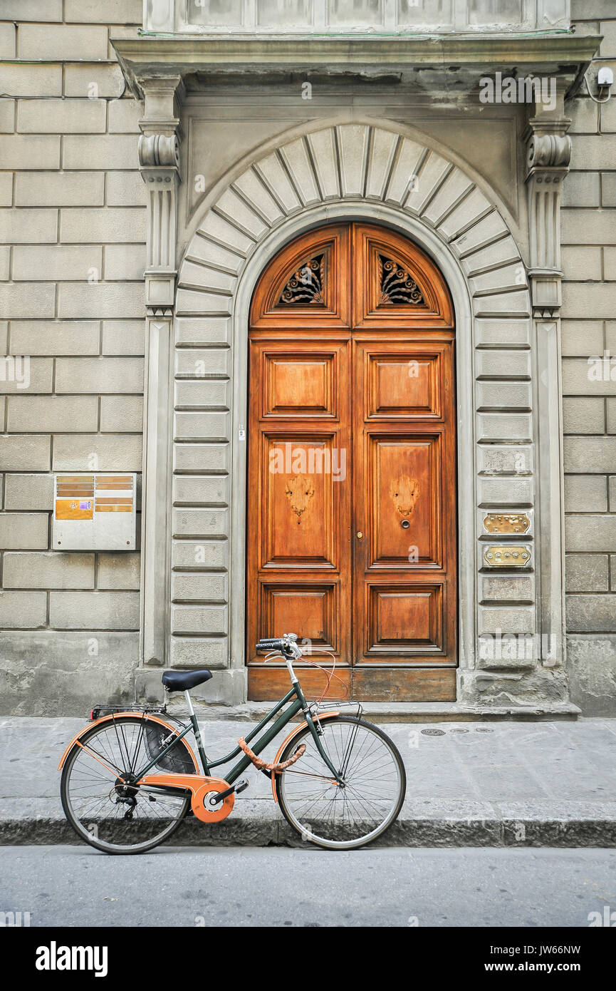 A bicycle stands against the curb outside a residential building in ...