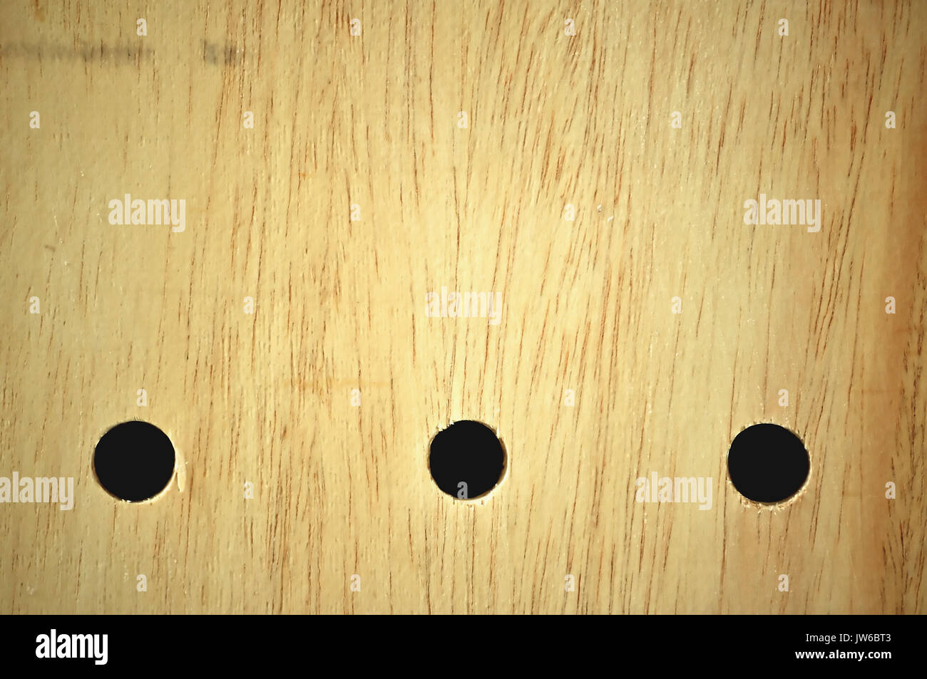 three hole on a wood board Stock Photo - Alamy